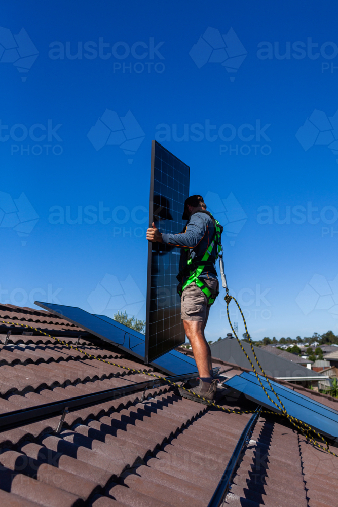 Image of bifacial solar panels being carried on rooftop during solar ...