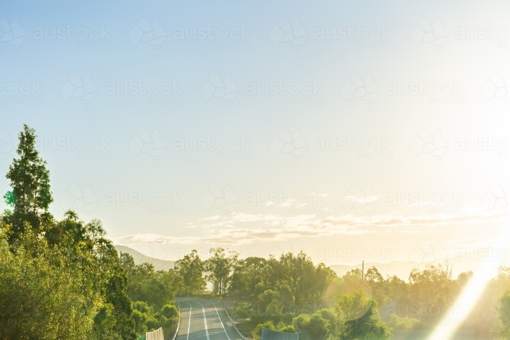 Image of Big hazy sky with sun flare near open cut mines - Austockphoto