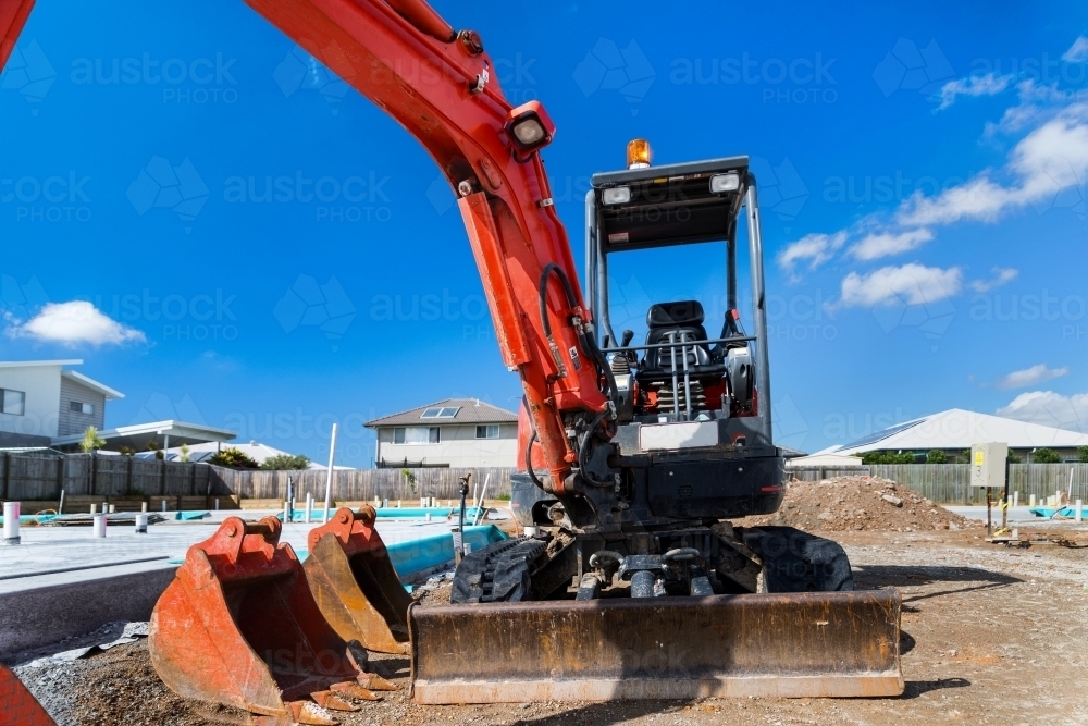 Image of Big red digger, scraper at a new construction development site ...