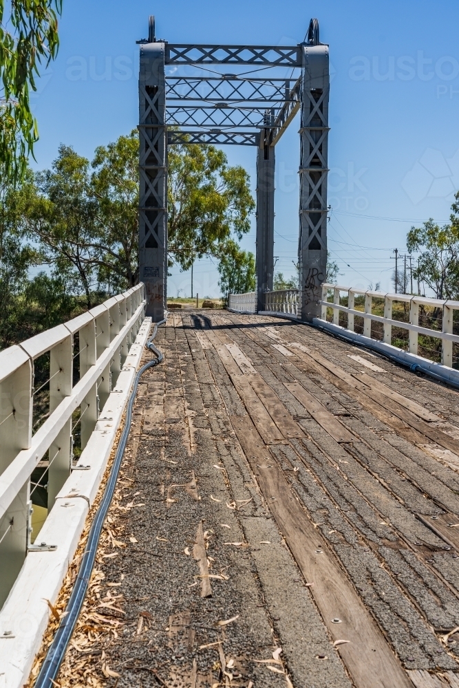 Image of Bitumen covered boards and white railings leading across an ...