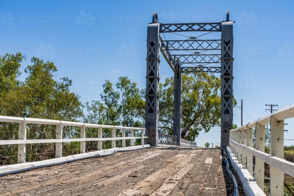 Image of Bitumen covered boards and white railings leading across an ...