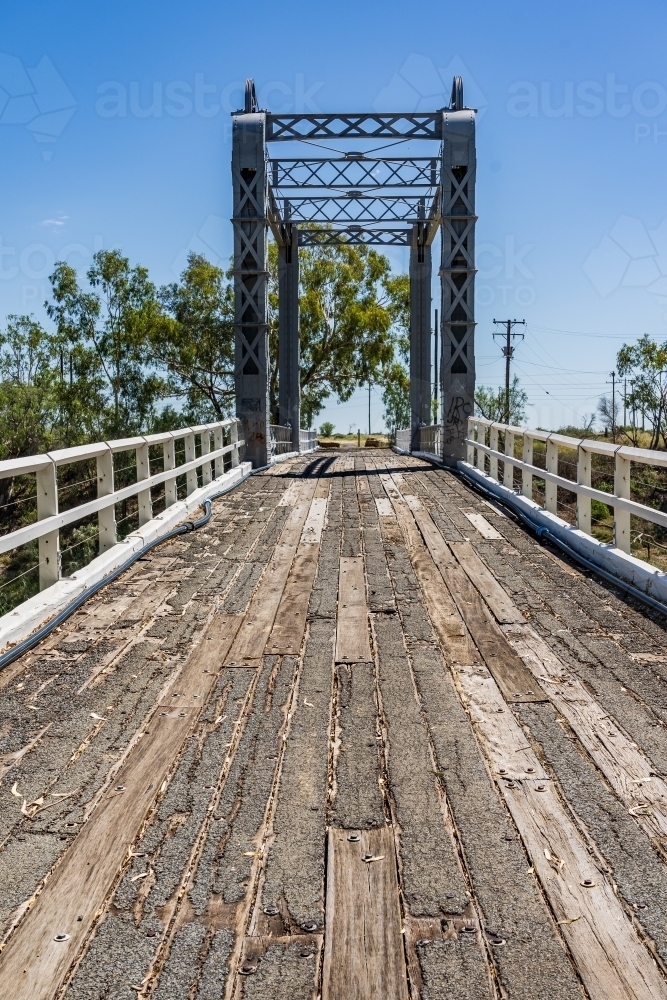 Image of Bitumen covered boards and white railings leading across an ...