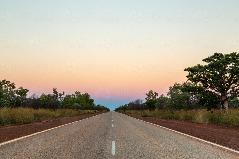 Image of Bitumen road and pastel sunset in Western Australia - Austockphoto