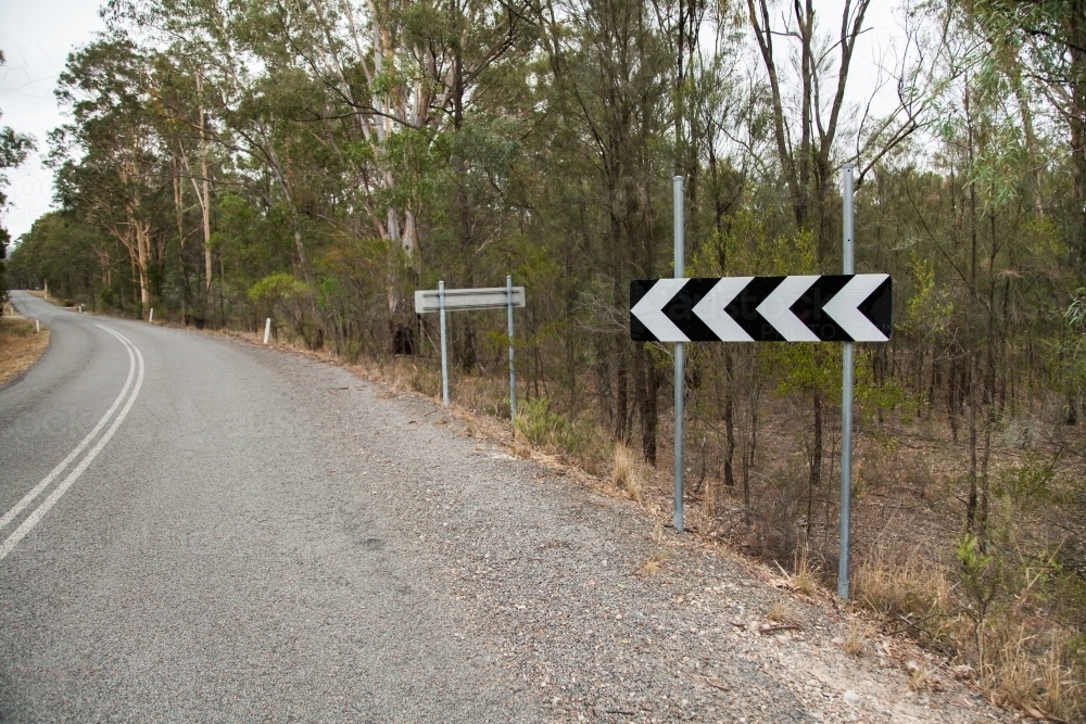 Image of Black and white sign warning of sharp corner bend in country ...