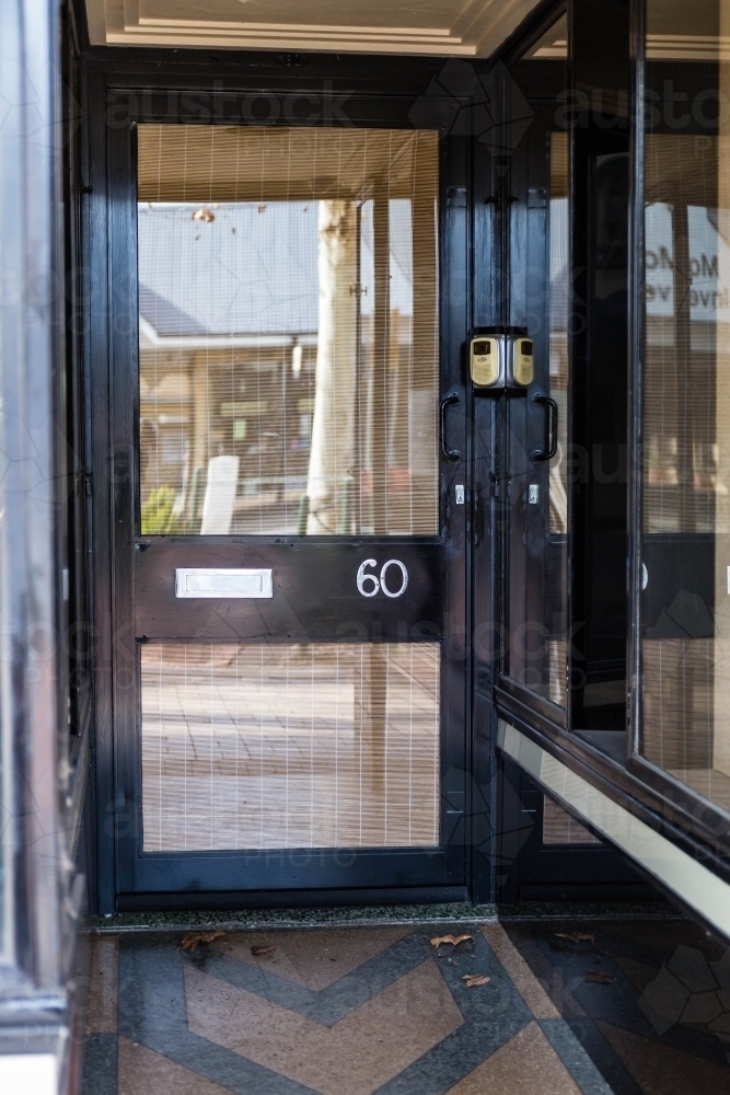 Image of Black door with glass with number 60 - Austockphoto