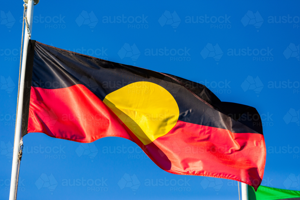 Image of Black yellow and red Aboriginal flag flying in blue sky ...