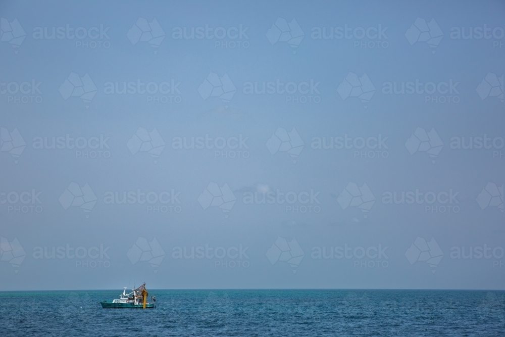 Image of blue fishing boat on the pacific ocean - Austockphoto