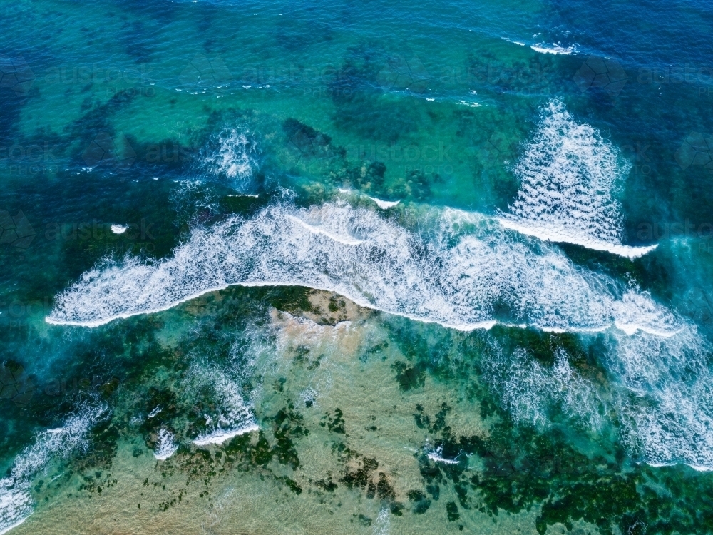 Image of blue green ocean water with waves incoming to shore - aerial ...