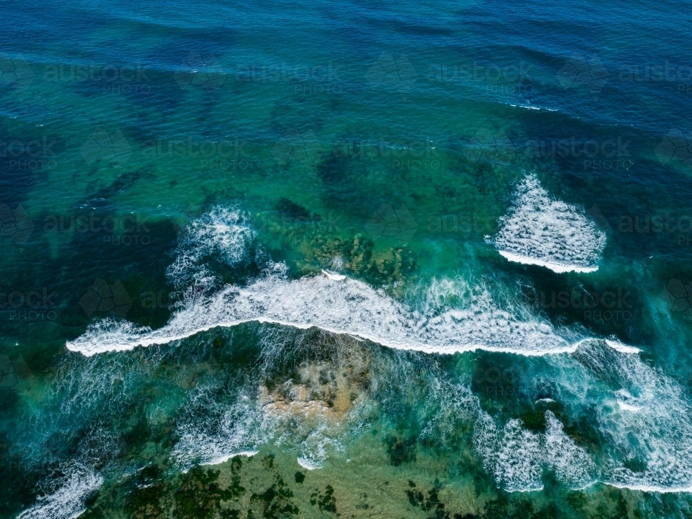 Image of blue green ocean water with waves incoming to shore - aerial ...