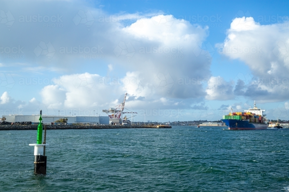 Image of Blue hulled container ship departing port. - Austockphoto