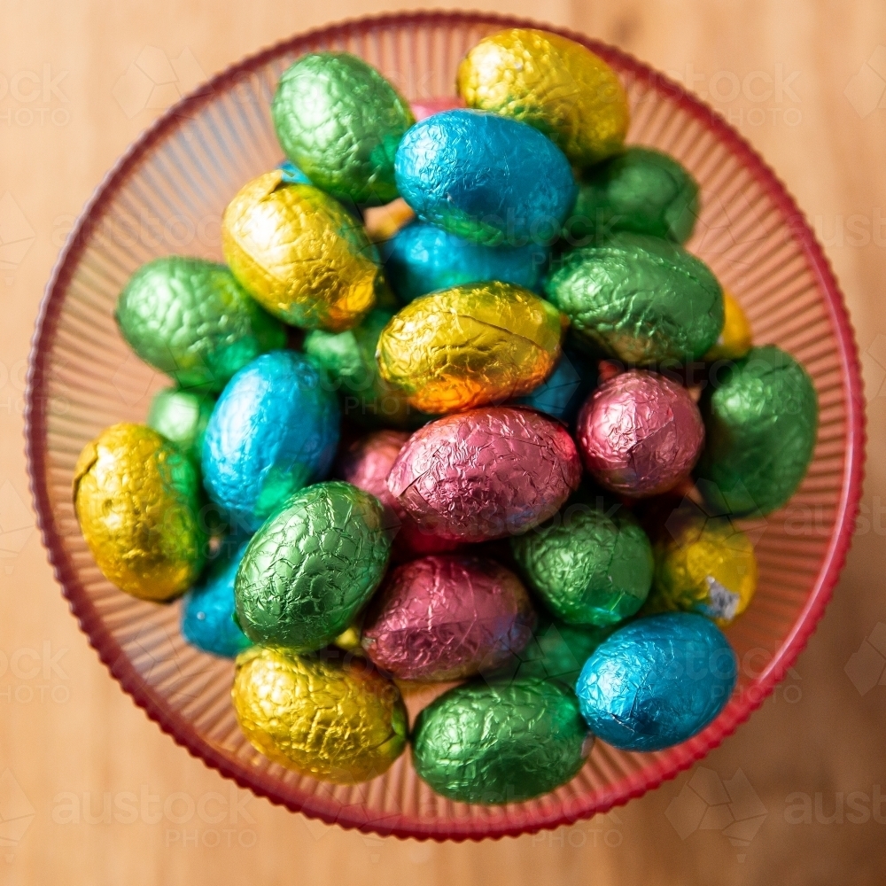 Image of bowl full of colourful easter eggs wrapped in shiny foil ...