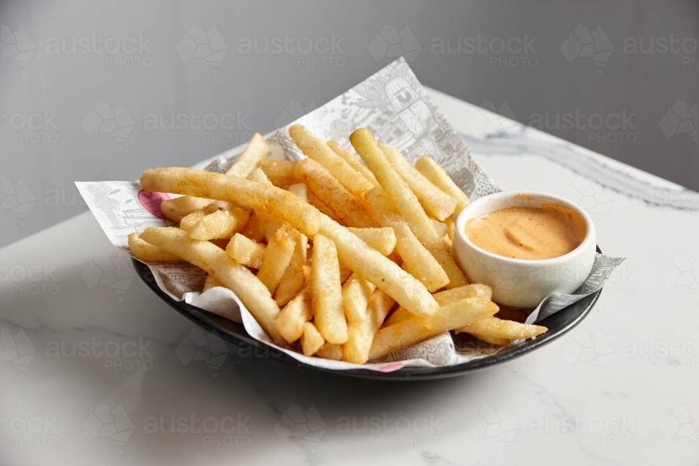 Image of Bowl of hot chips with dipping sauce - Austockphoto