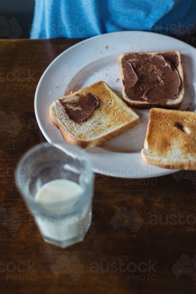 Image of boy eating breakfast, spreading toast - Austockphoto