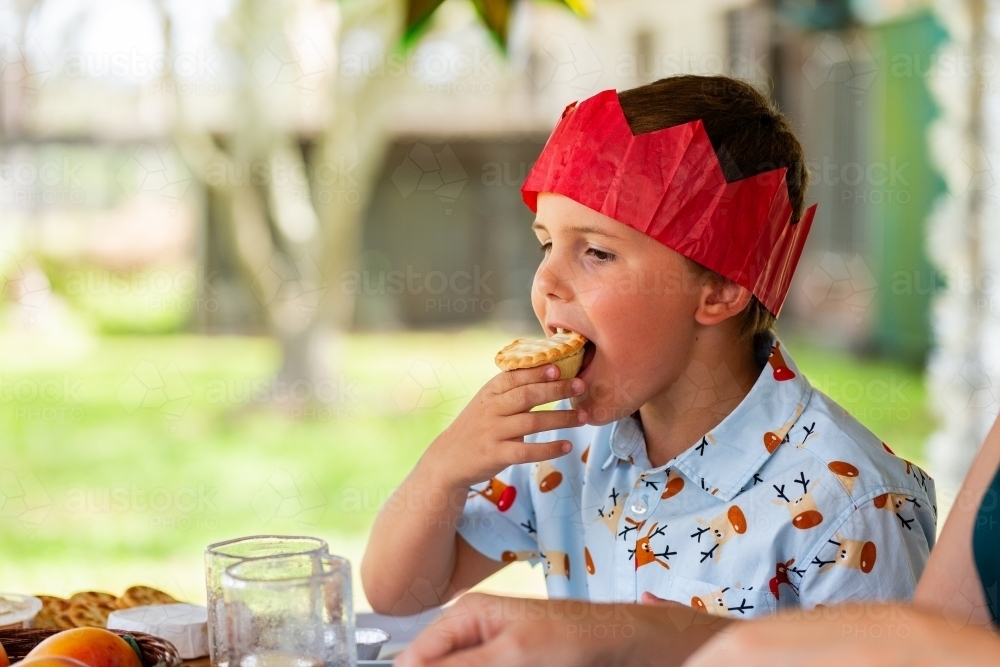 Image of boy eating fruit mince pie while family is distracted serving ...