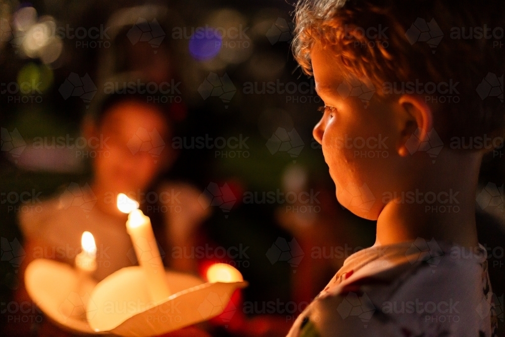 Image of boy holding a real candle at carols by candlelight - Austockphoto