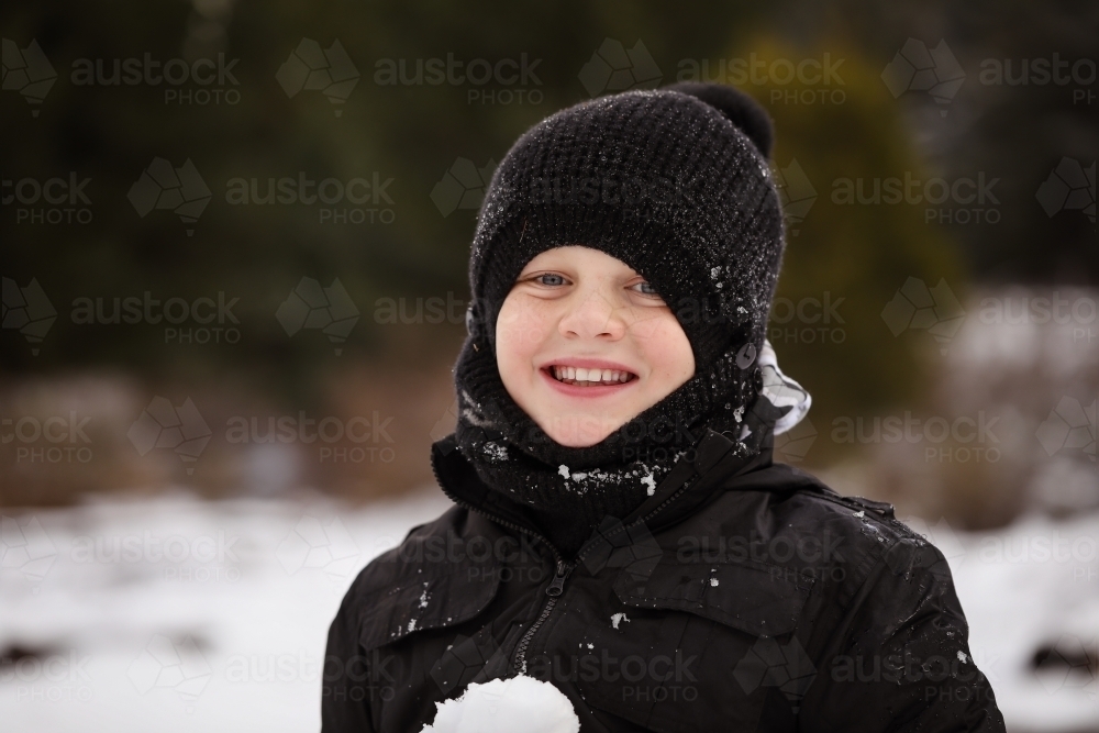 Image of Boy in the snow with snow ball having snowball fight ...