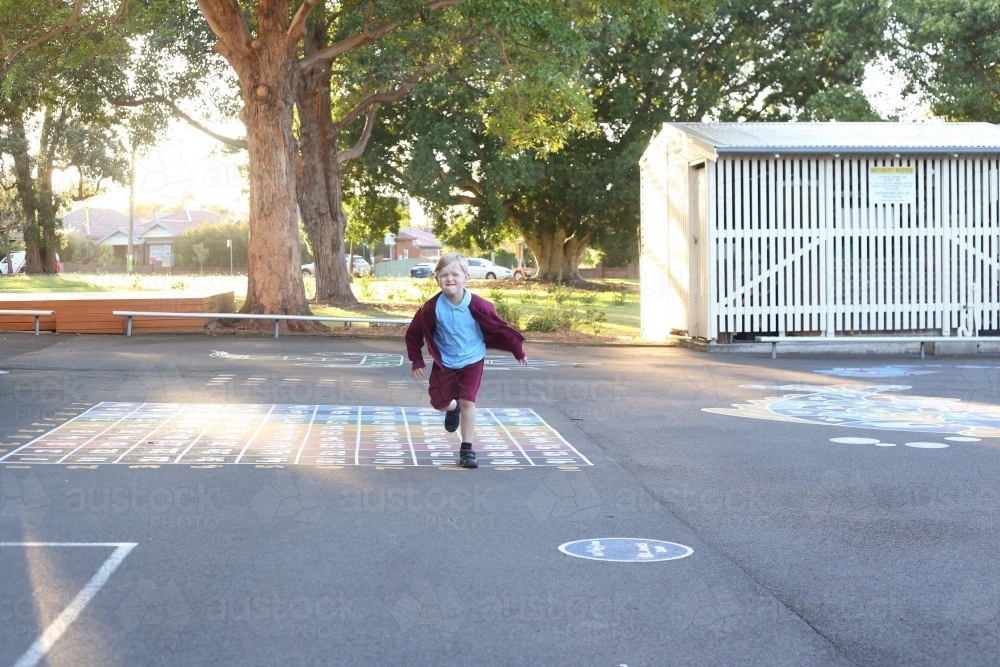 Image of Boy running through the school playground - Austockphoto
