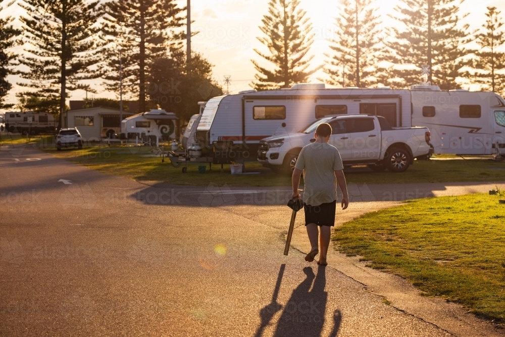 Image of Boy walking through caravan park in golden afternoon light ...