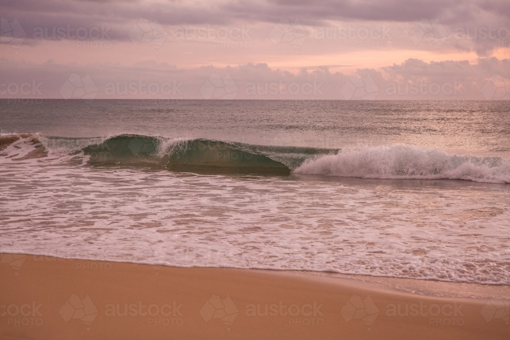 Image of breaking wave at dawn - Austockphoto
