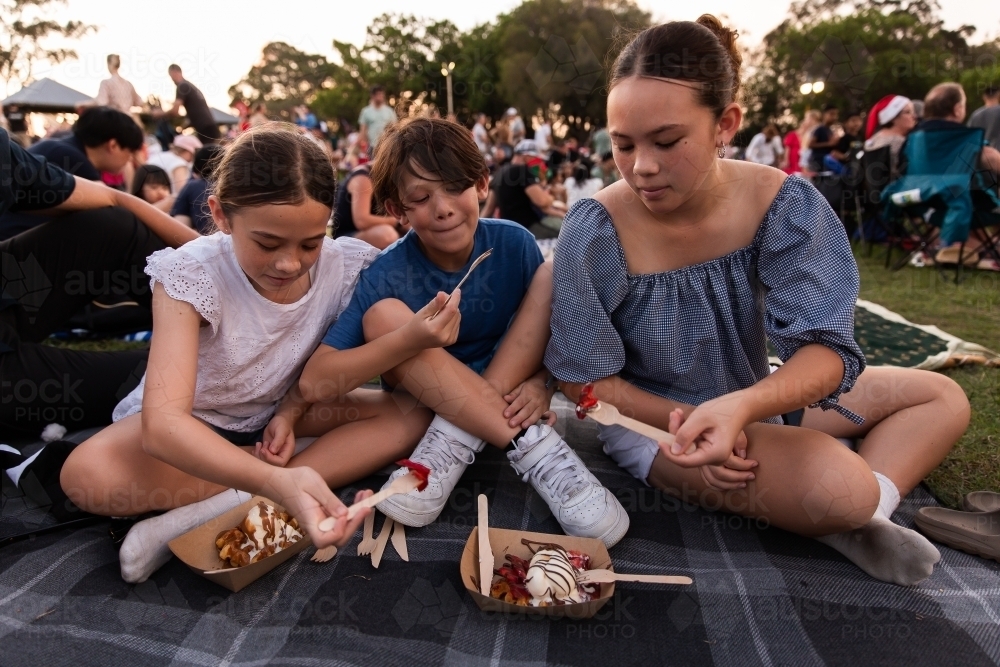 Image of brother and sisters sharing waffles from a food truck at the ...