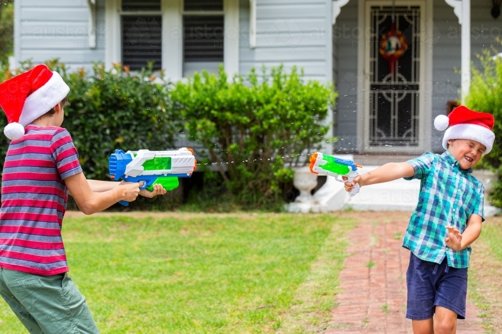 Image of Brothers pointing blaster pistols in Christmastime water fight ...