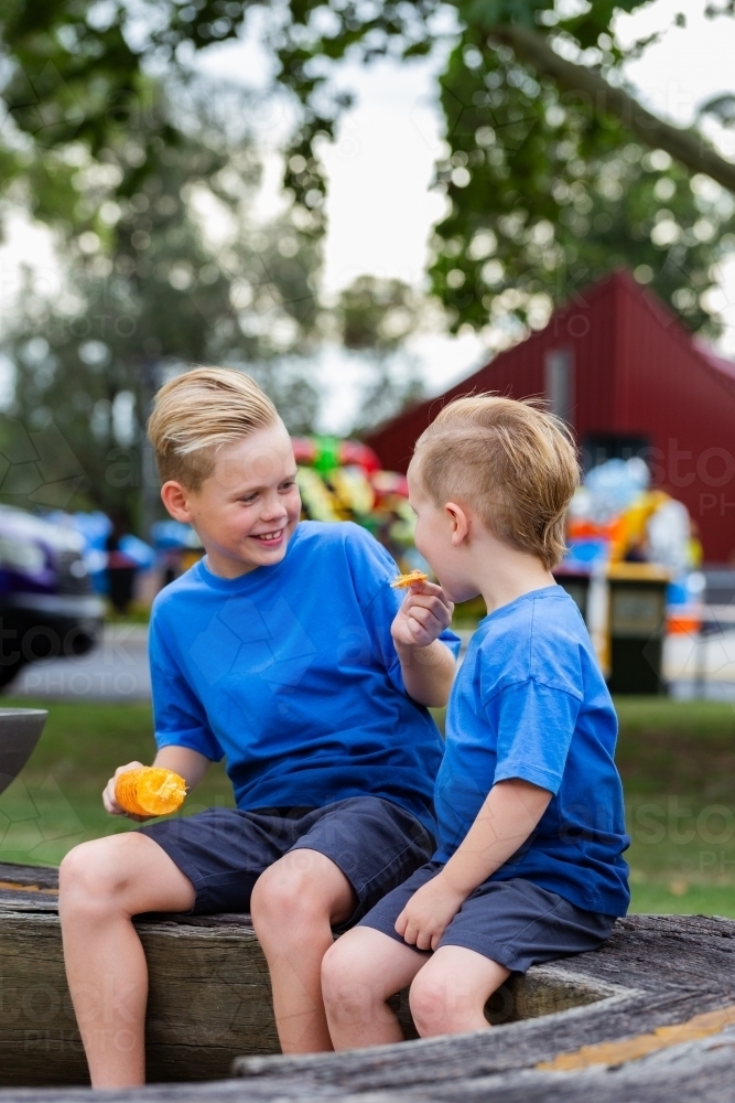 Image of brothers sharing hot chips on a stick – tornado potatoes ...