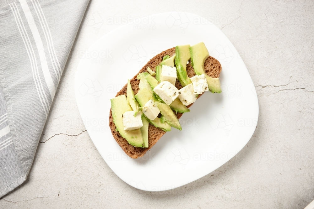 Image of Brown bread topped with sliced avocado and cheese - Austockphoto