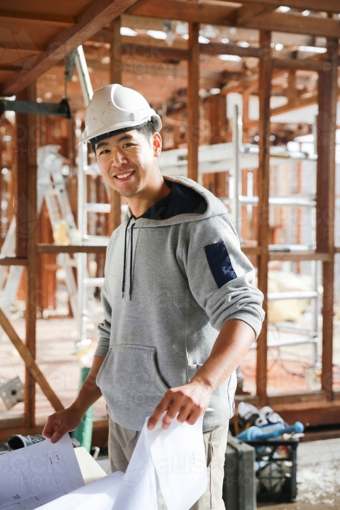 Image of Builder checking construction plans on-site - Austockphoto