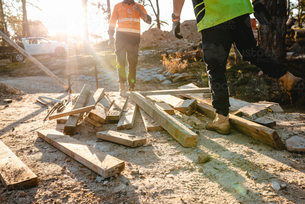 Image of Builders sorting and checking wooden planks on the ground ...