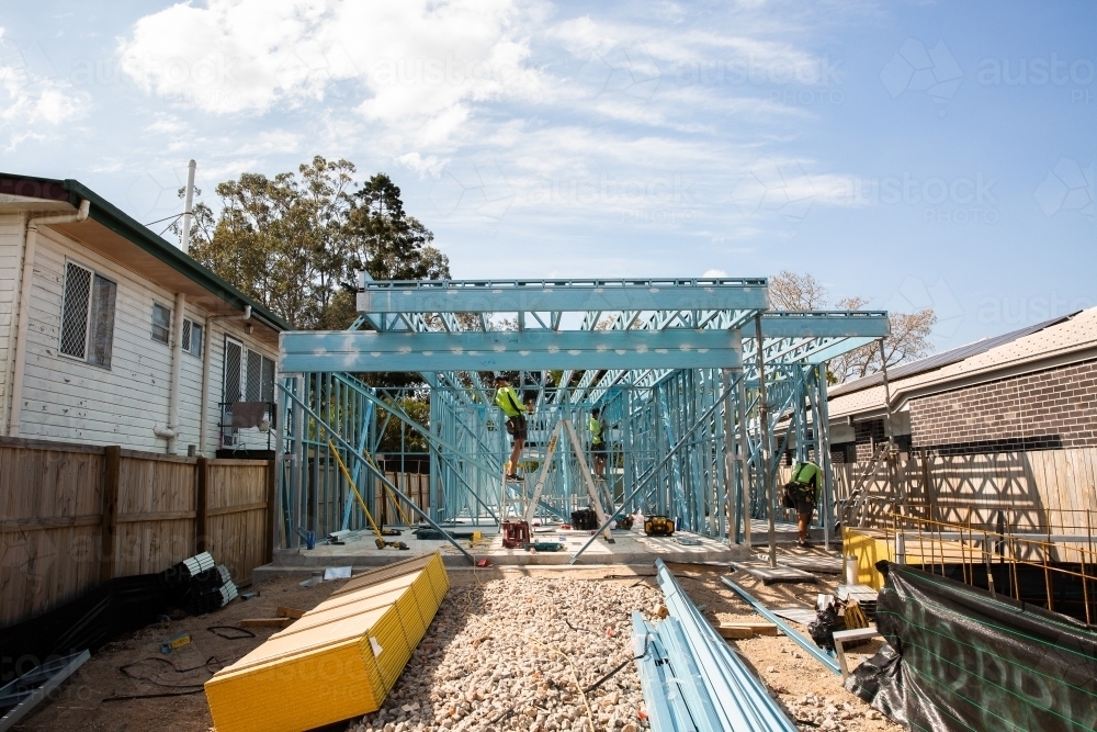 Image of builders working on a steel frame house construction in ...