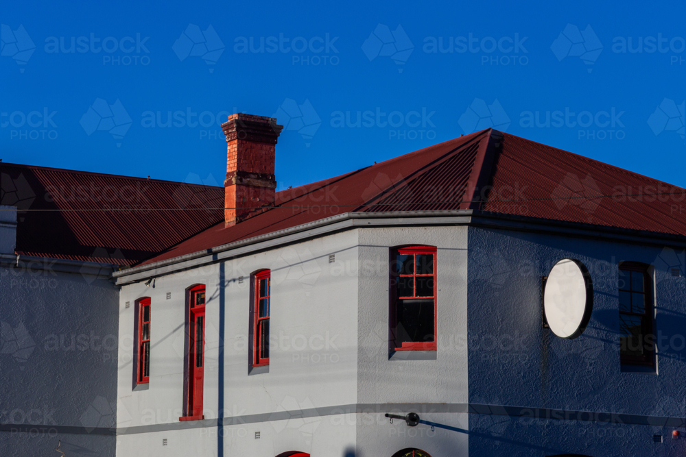 Image of building with red roof and grey facade - Austockphoto