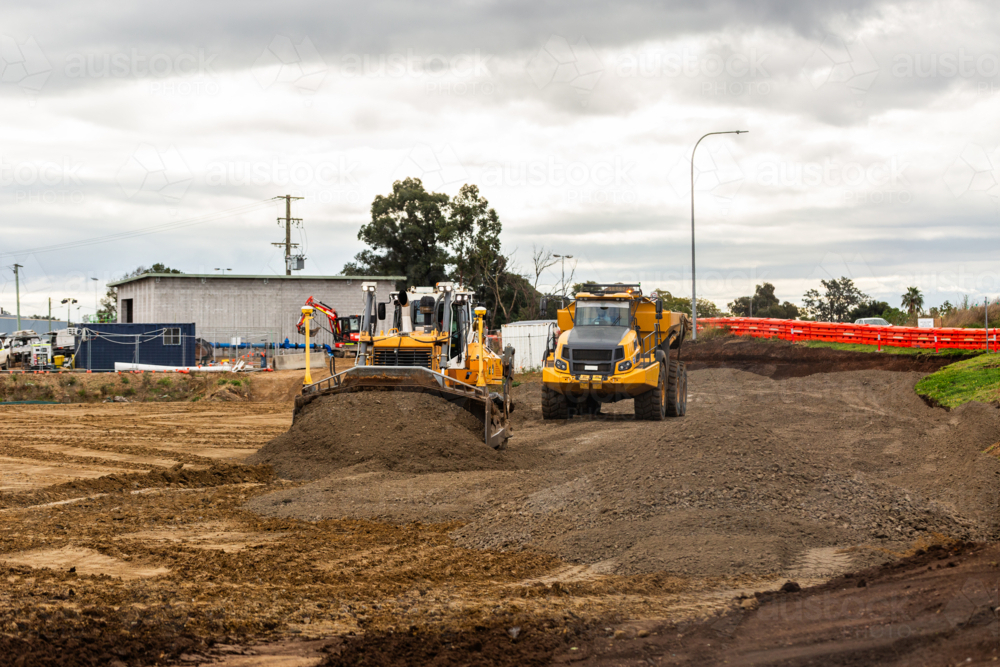 Image of bulldozer and dump truck on construction site with earthworks ...