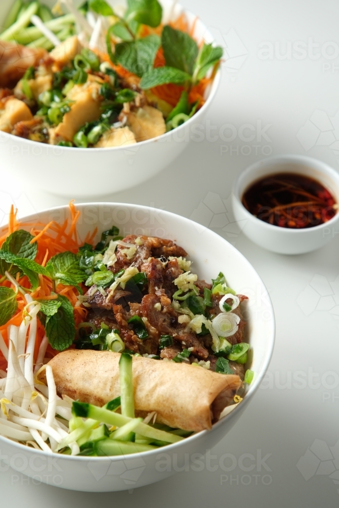 Image of Bun Cha Gio bowls on a white countertop with a small dish of ...