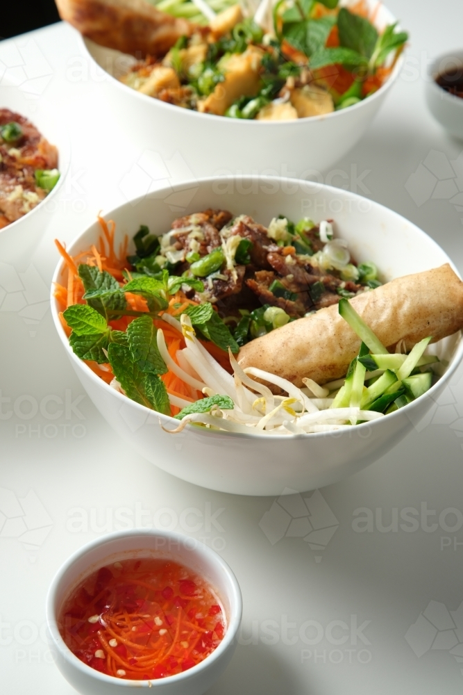 Image of Bun Cha Gio bowls on a white countertop with a small dish of ...