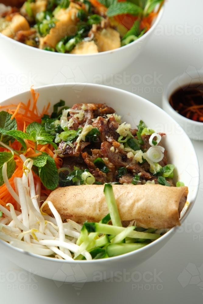 Image of Bun Cha Gio bowls on a white countertop with a small dish of ...