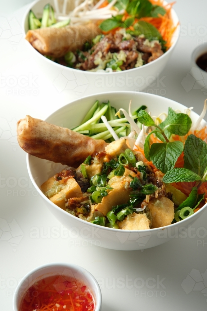 Image of Bun Cha Gio bowls on a white countertop with a small dish of ...