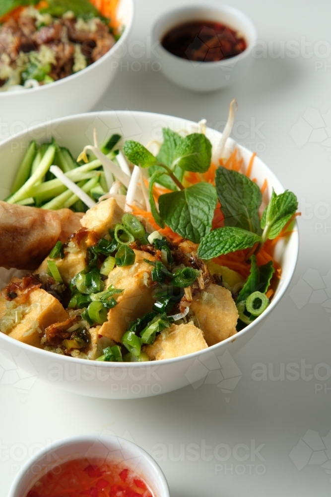 Image of Bun Cha Gio bowls on a white countertop with a small dish of ...