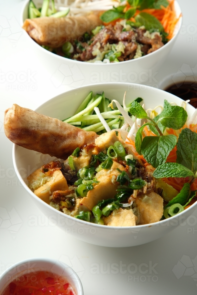 Image of Bun Cha Gio bowls on a white countertop with a small dish of ...