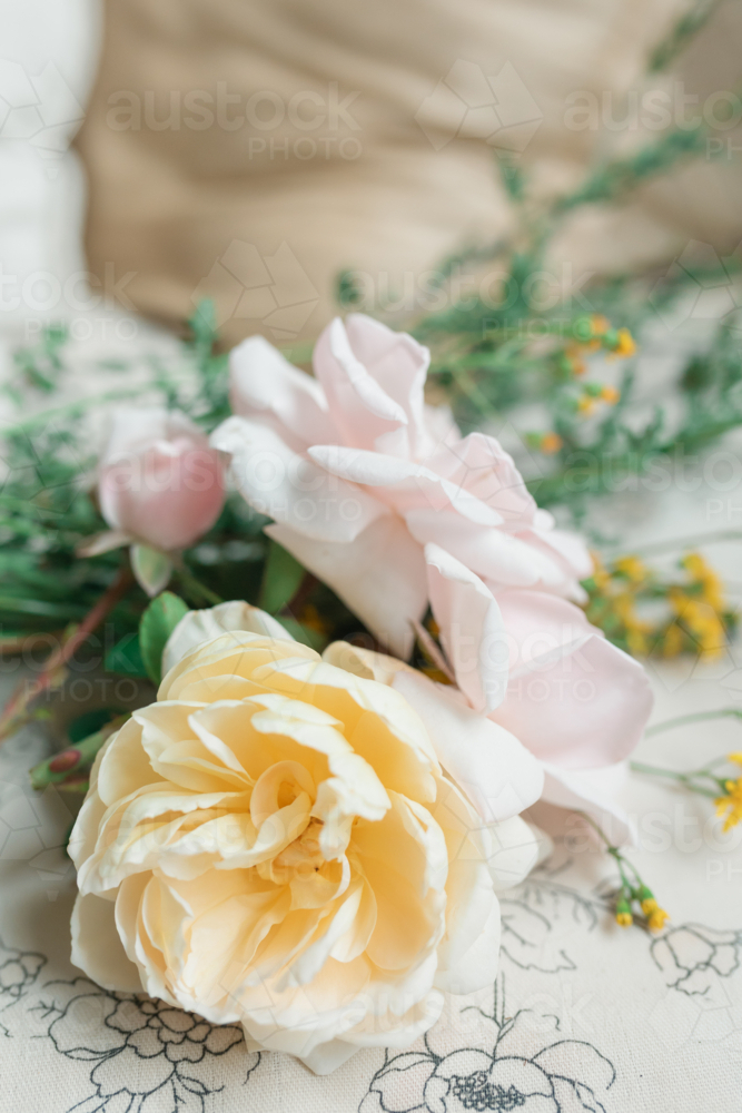 Image of Bunch of fresh flowers laying on floral sofa - Austockphoto