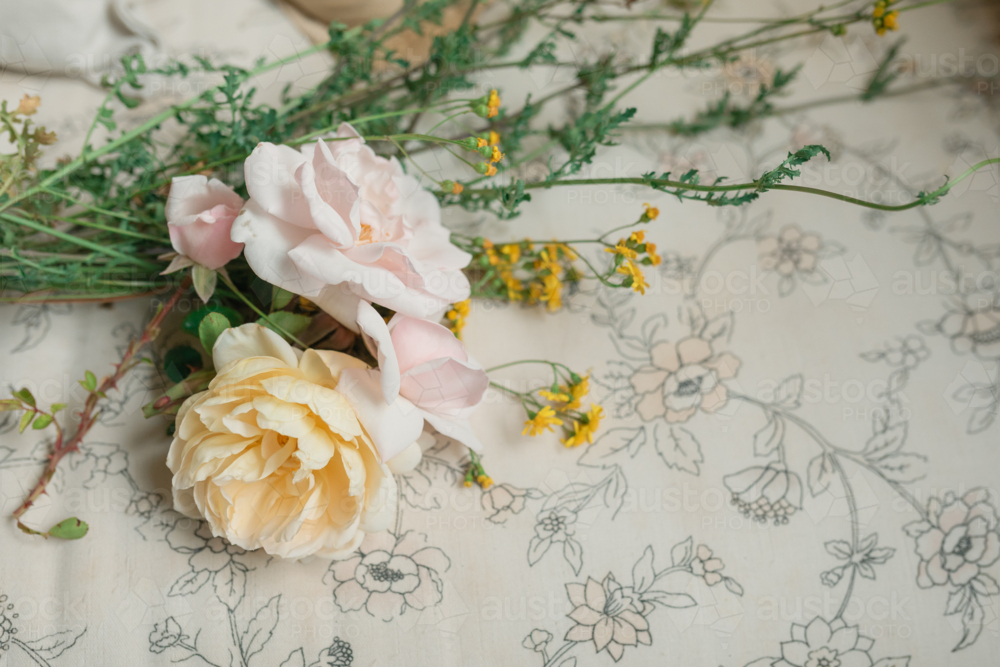 Image of Bunch of fresh flowers laying on floral sofa - Austockphoto