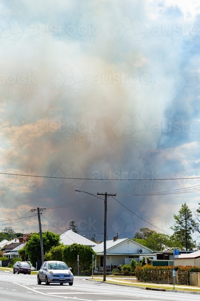 Image of Bushfire smoke billowing into sky behind houses along main ...