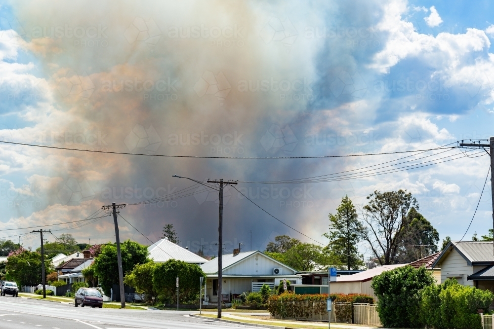 Image of Bushfire smoke billowing into sky behind houses along main ...