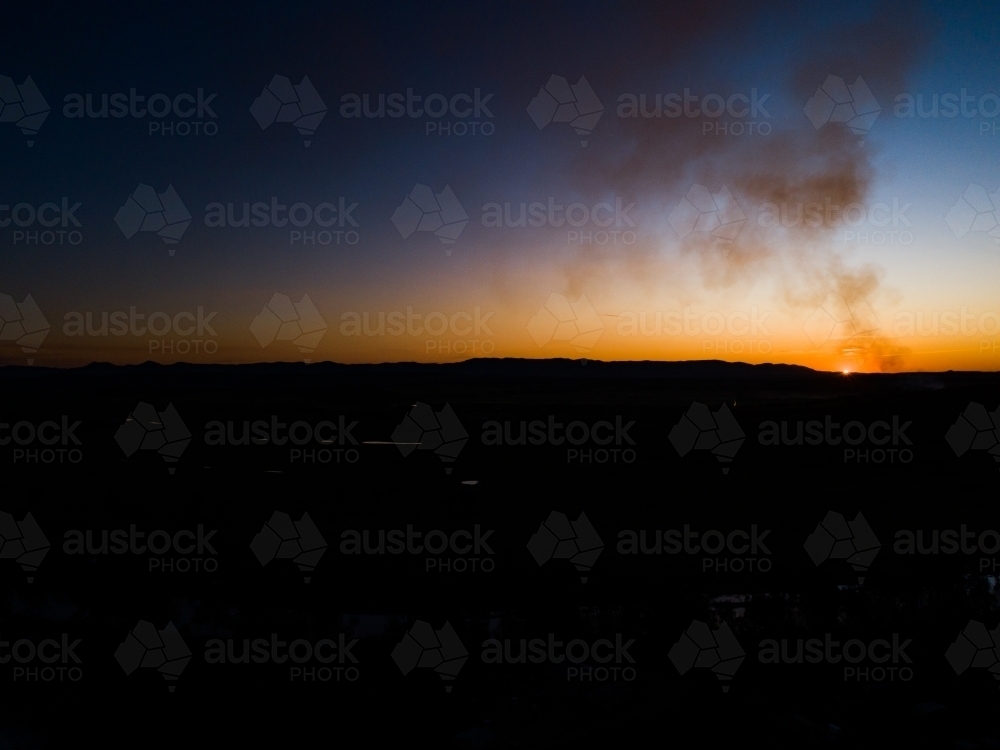 Image of bushfire smoke on horizon after sunset - Austockphoto