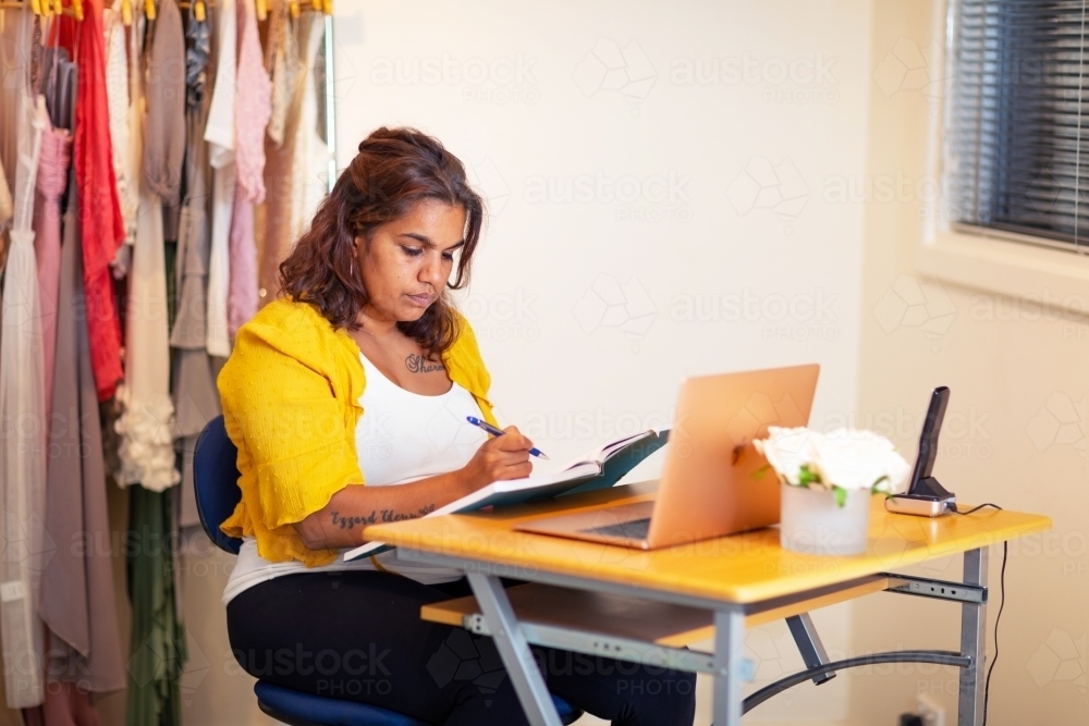 Image of businesswoman working at small desk at home - Austockphoto