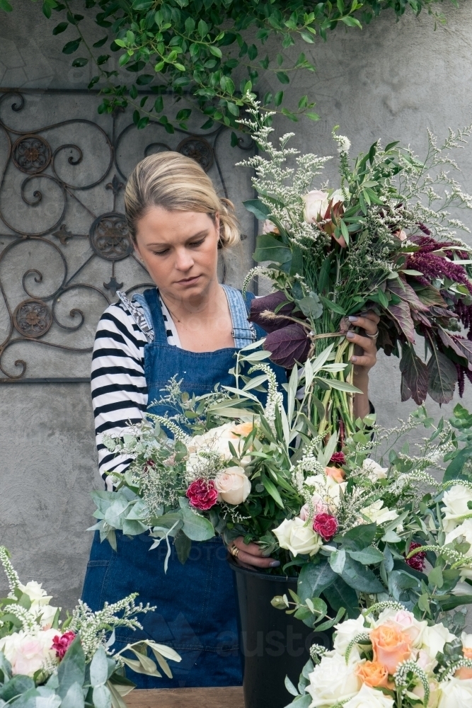Image of Busy woman making big bunches of flowers - Austockphoto