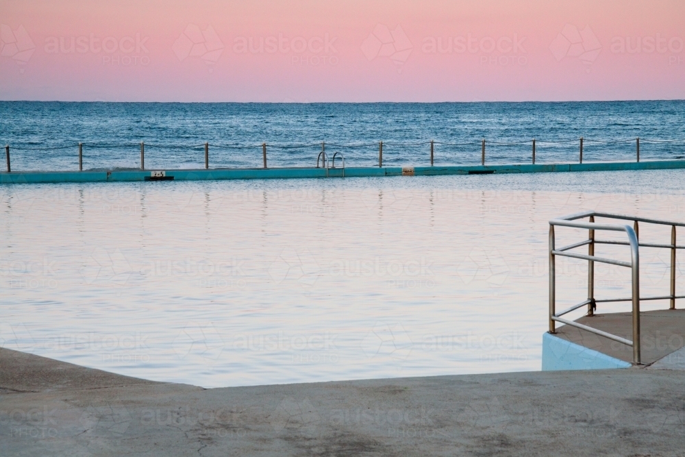 Image of Calm tidal baths next to a choppy sea with pastel colours in ...