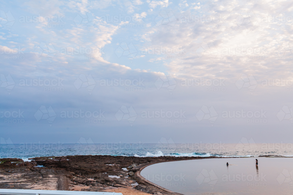 Image of calm water of Newcastle Canoe Pool with big sky and soft cloud ...