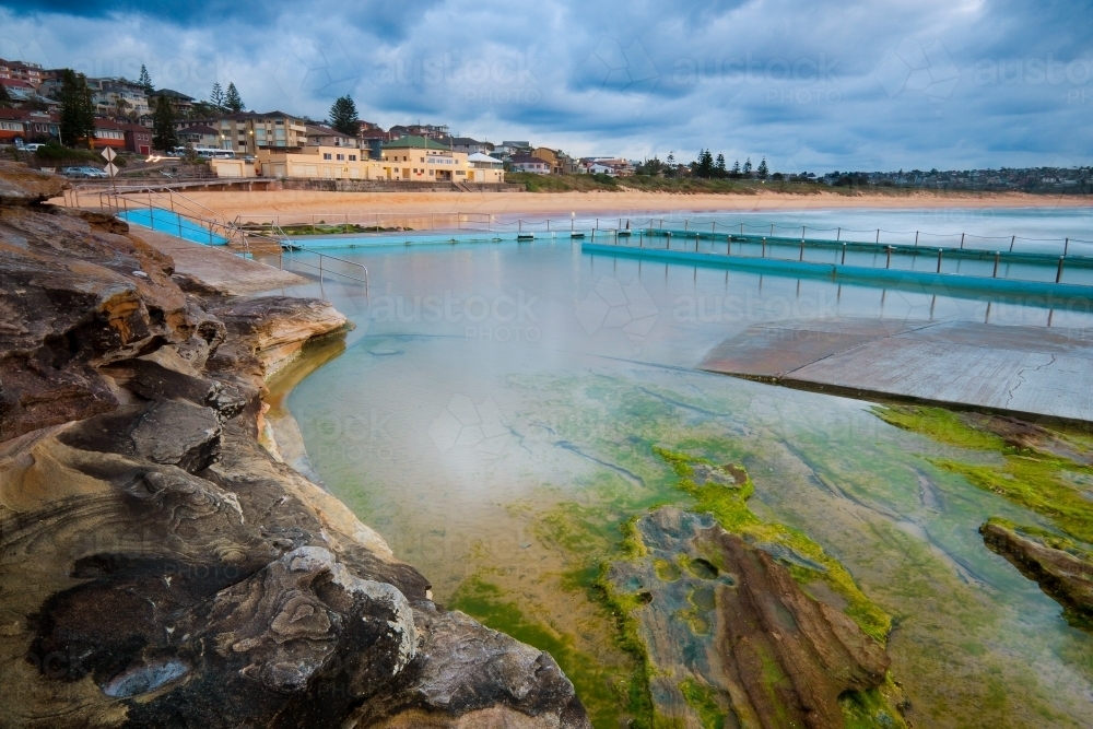 Image of Calm waters of tidal swimming baths and a surf club building ...
