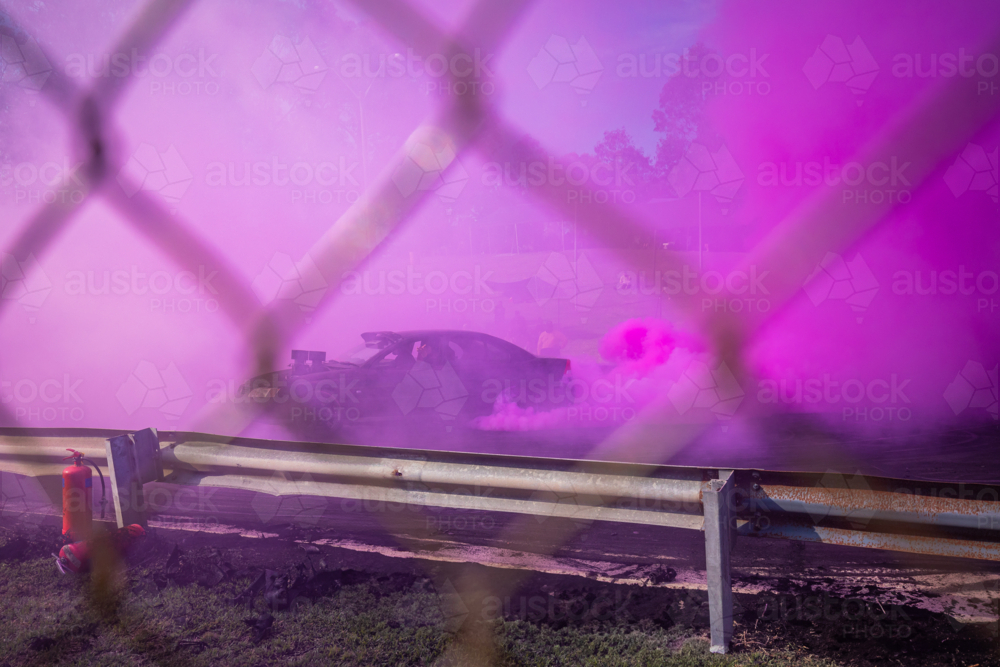 Image of Car doing burnout in competition causing pink smoke - Austockphoto