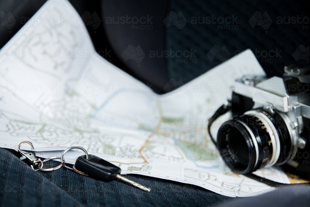 Image of Car keys and vintage film camera with map on car seat ...
